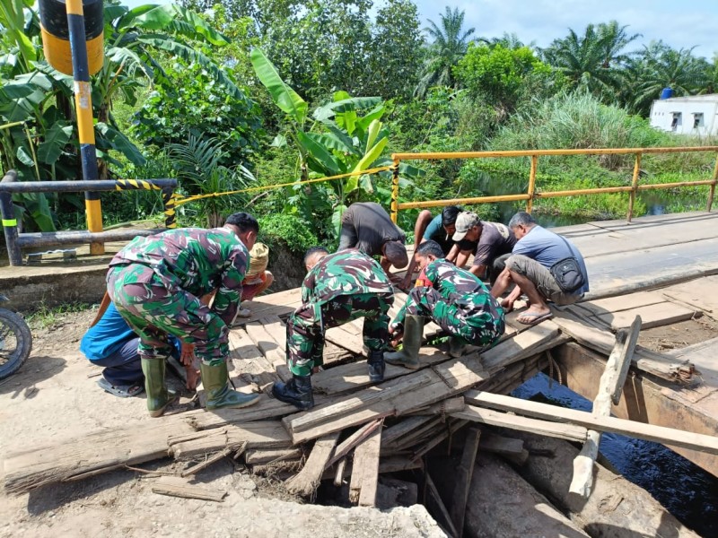 Empat Anggota Koramil 0321-05/ RM dan Warga Gotong Royong Perbaiki Jembatan Rusak